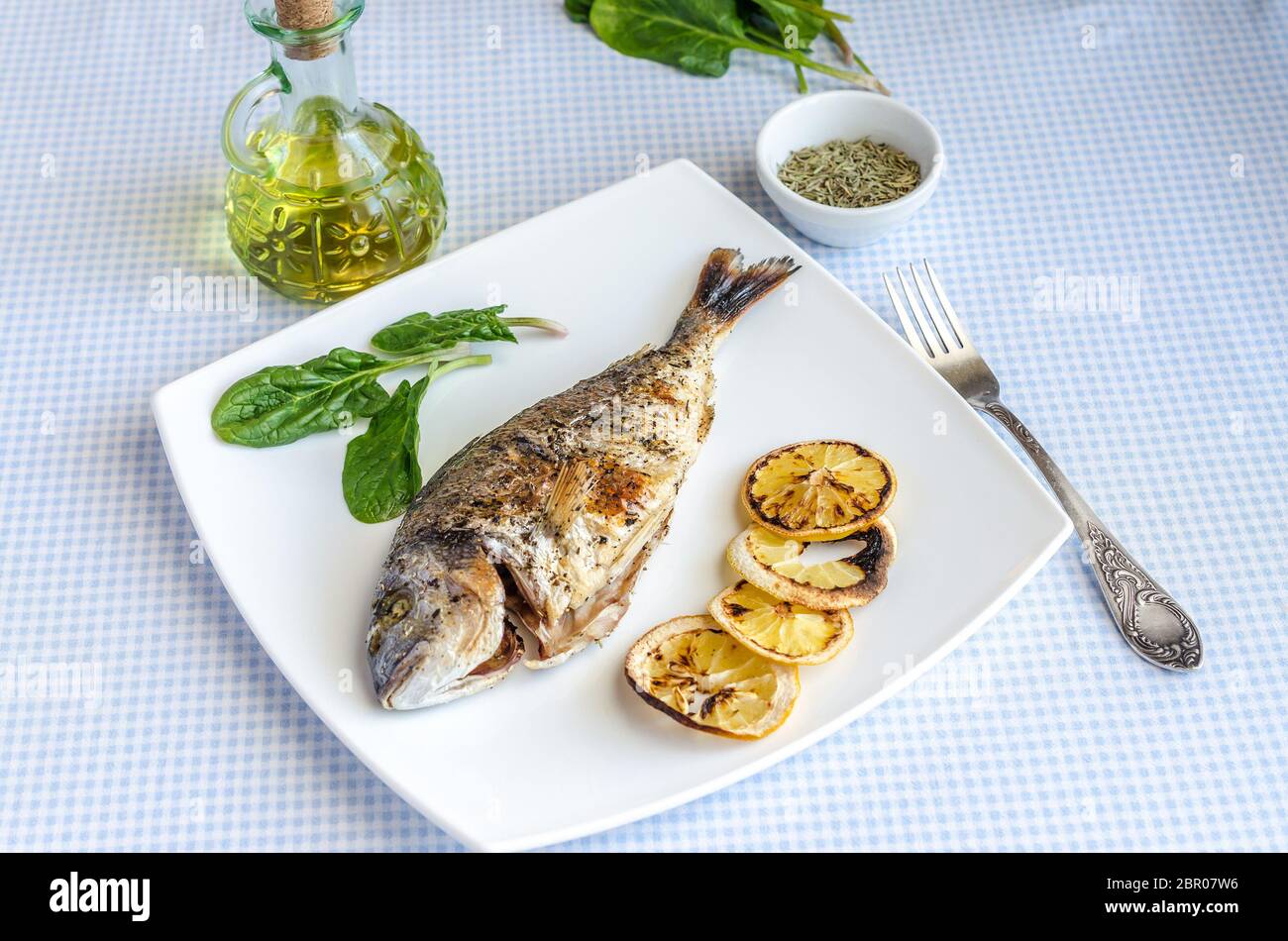 Grilled dorada fish with lemon and spinach Stock Photo - Alamy