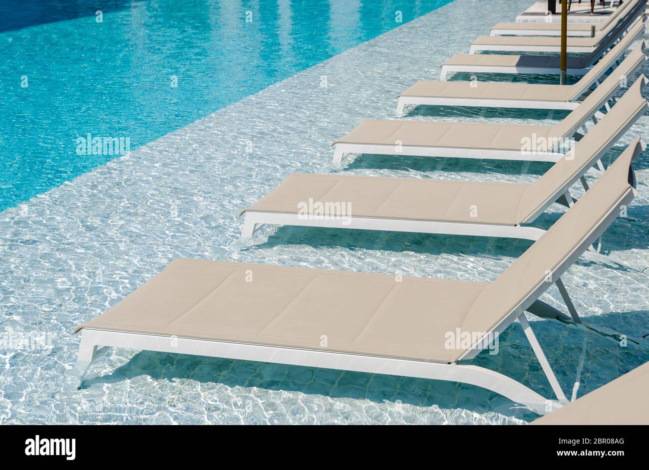 Turquoise swimming pool with clean water and sunbeds Stock Photo - Alamy