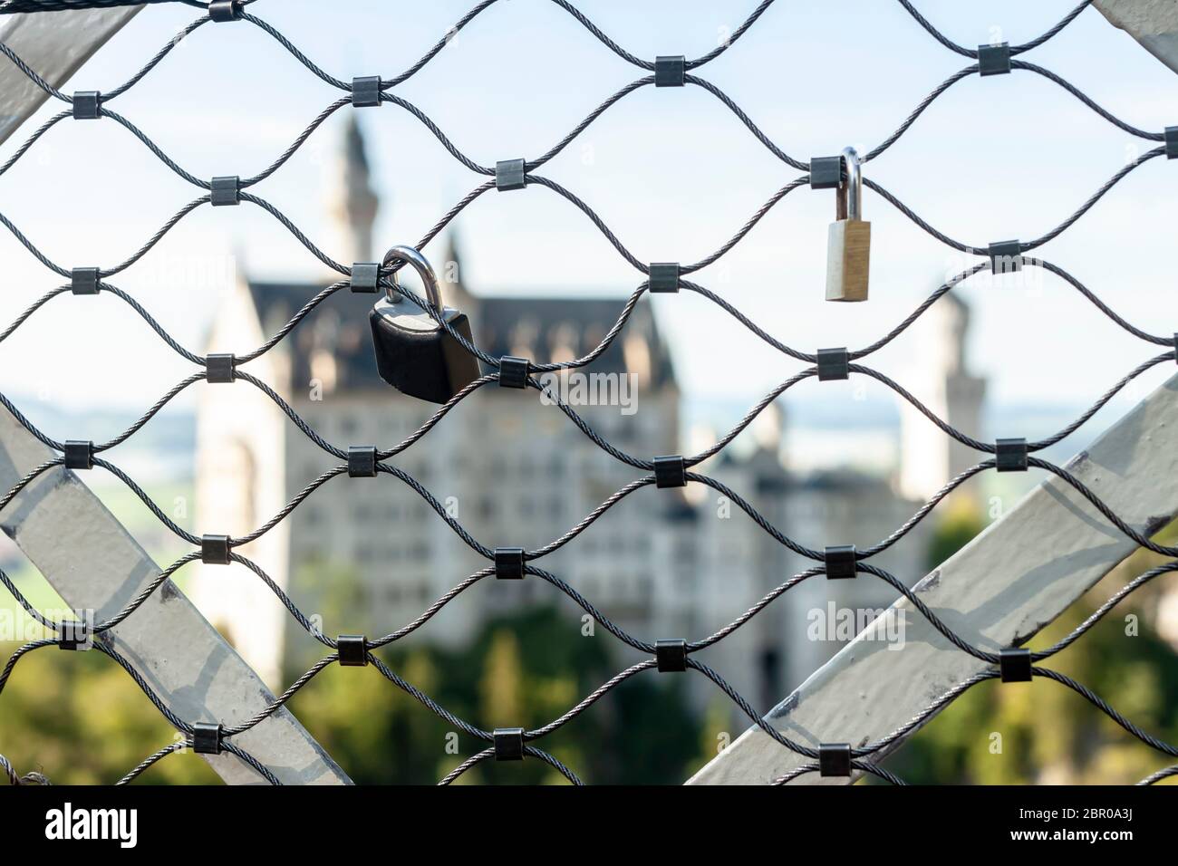 Sunny day blurred castle Neuschwanstein behind rabitz fence landscape ...