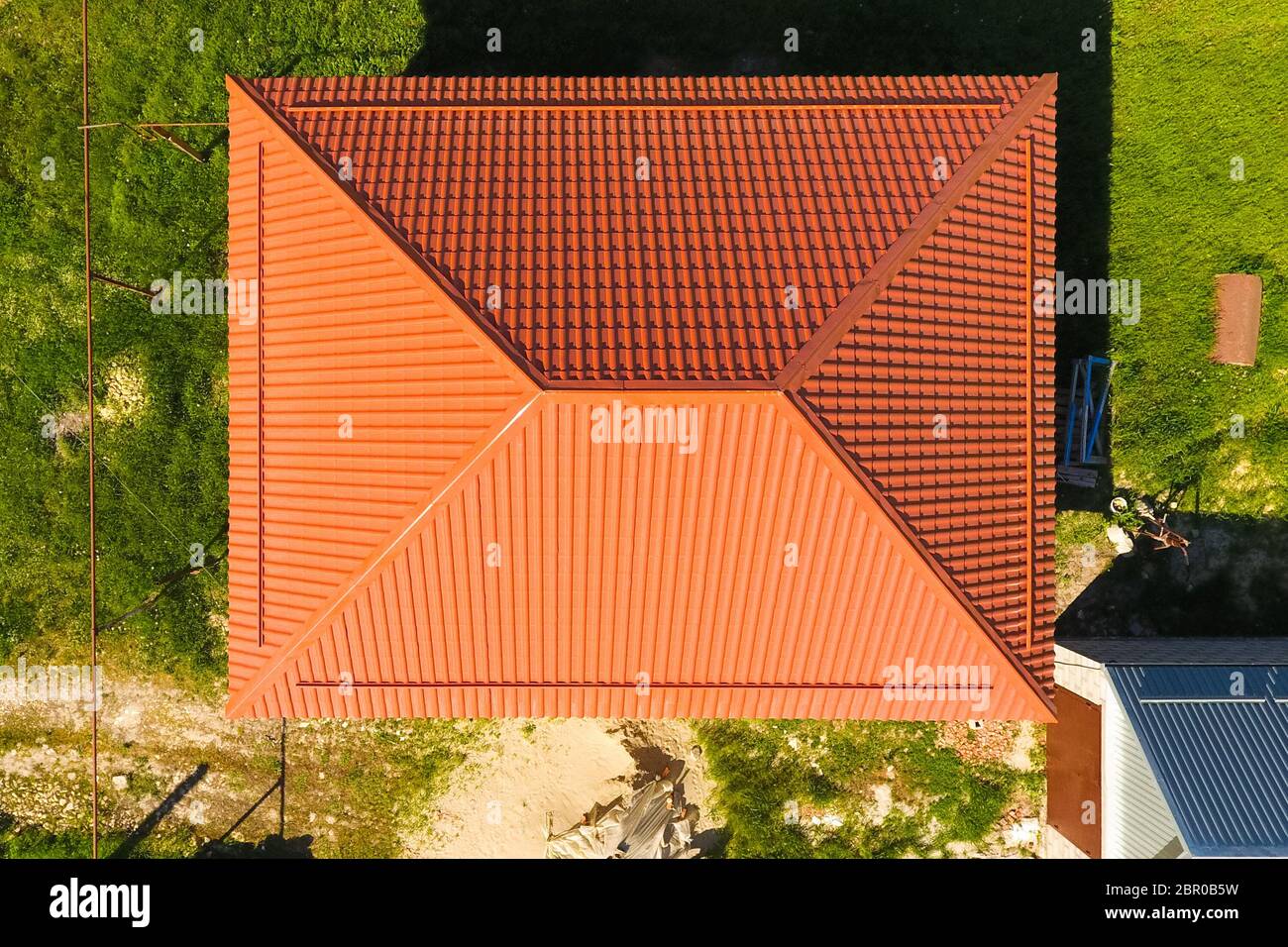 House with an orange roof made of metal, top view. Metallic profile ...