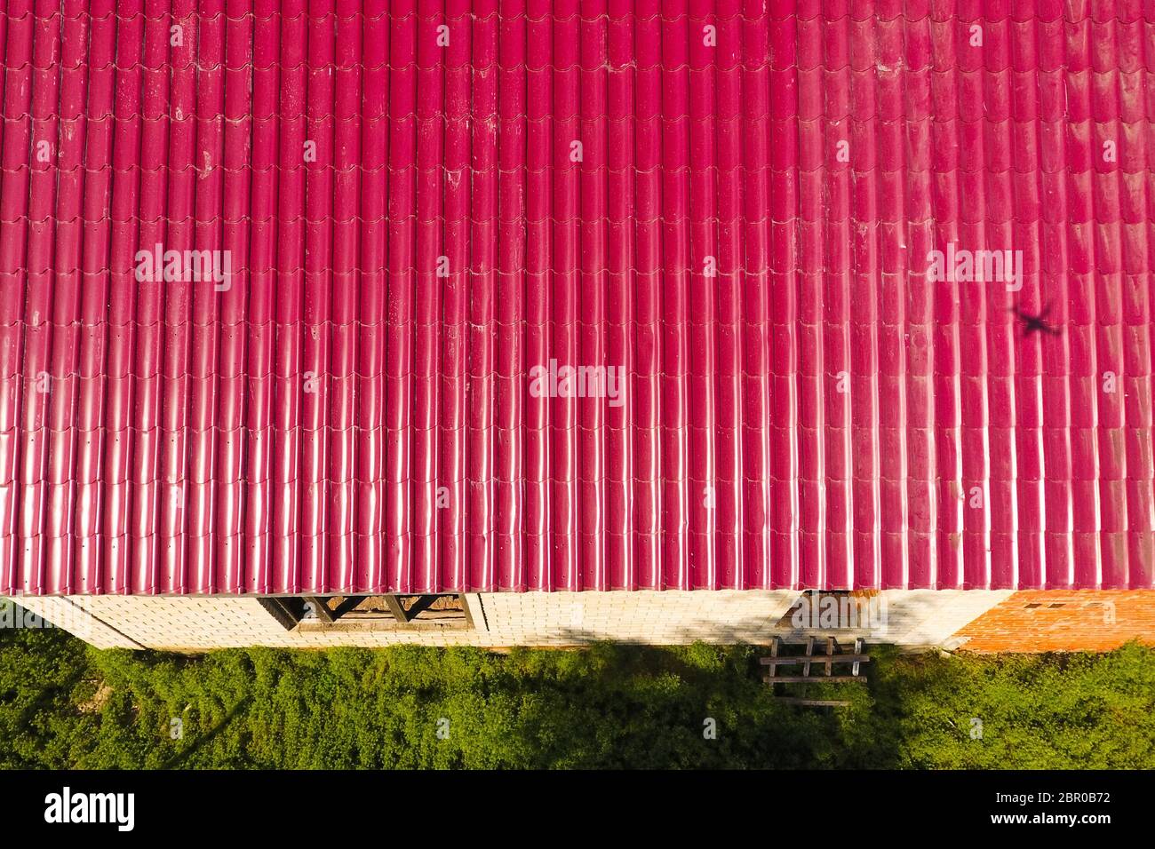 A house with a red roof made of corrugated metal sheets. Roof from ...