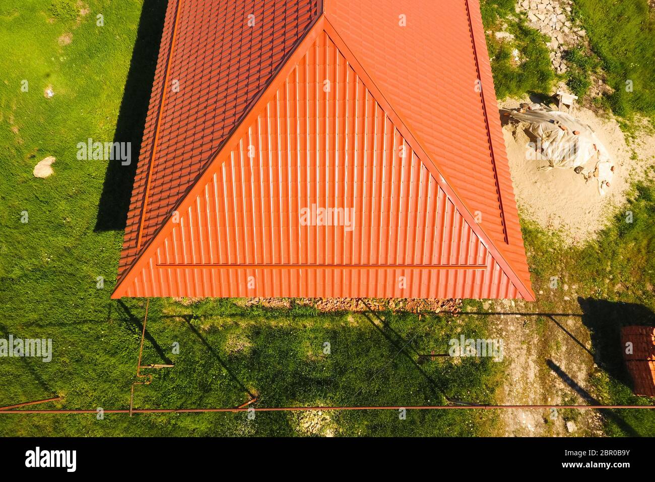 House with an orange roof made of metal, top view. Metallic profile ...