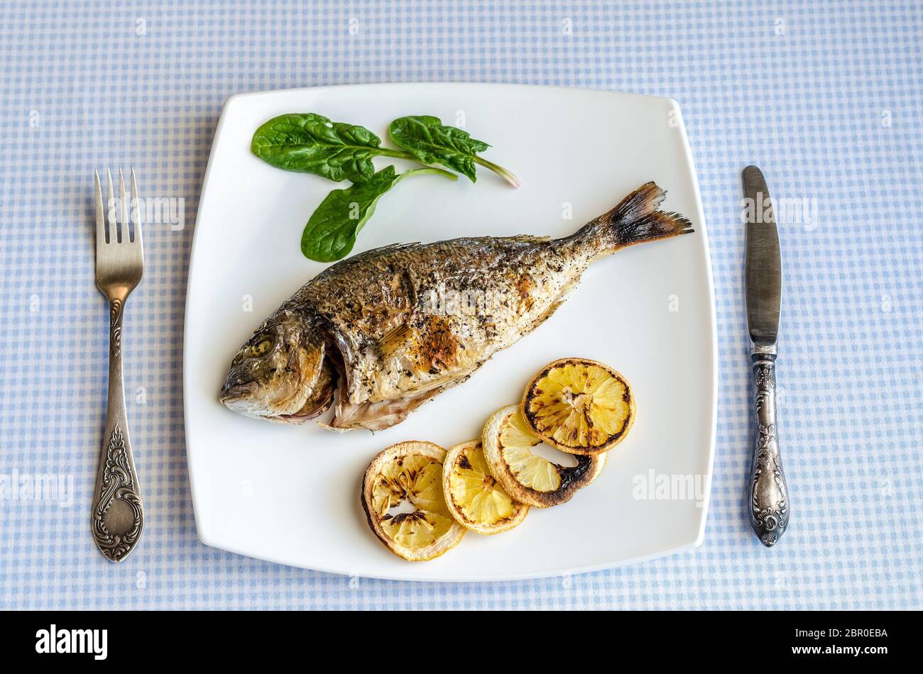 Grilled dorada fish with lemon and spinach Stock Photo - Alamy