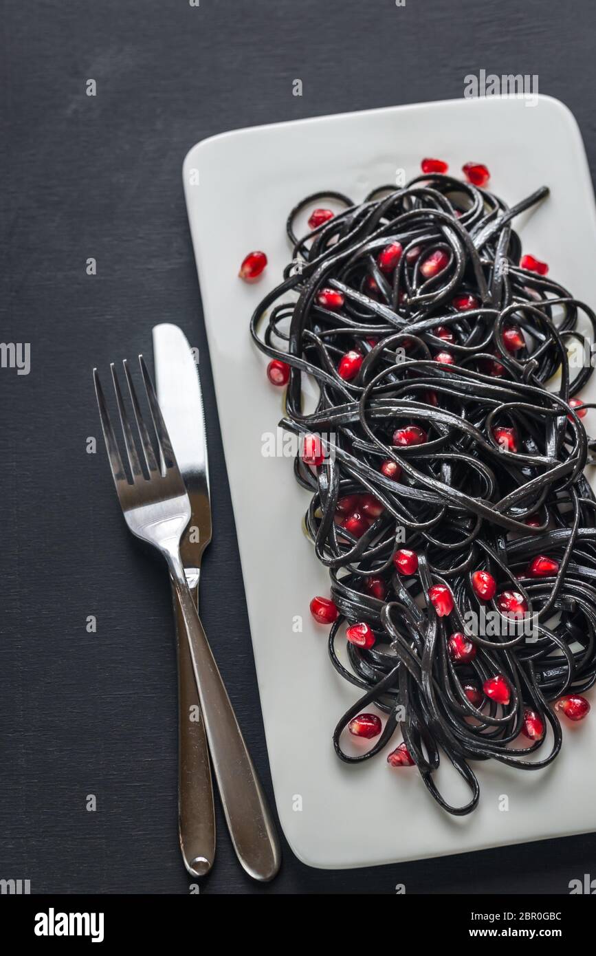 Black pasta with pomegranate seeds Stock Photo - Alamy