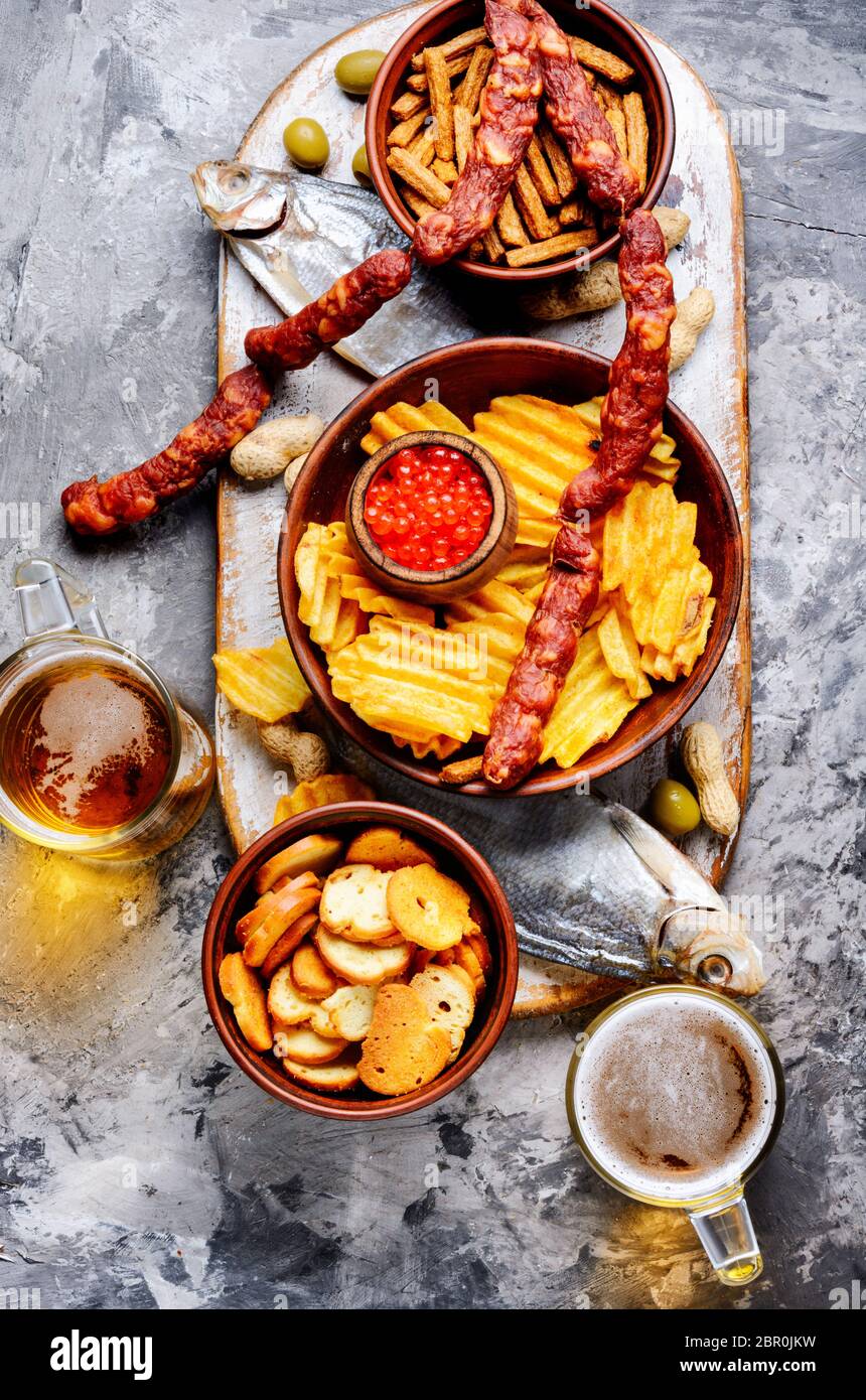 Beer and snacks.Chips, fish, beer sausages on the table Stock Photo - Alamy