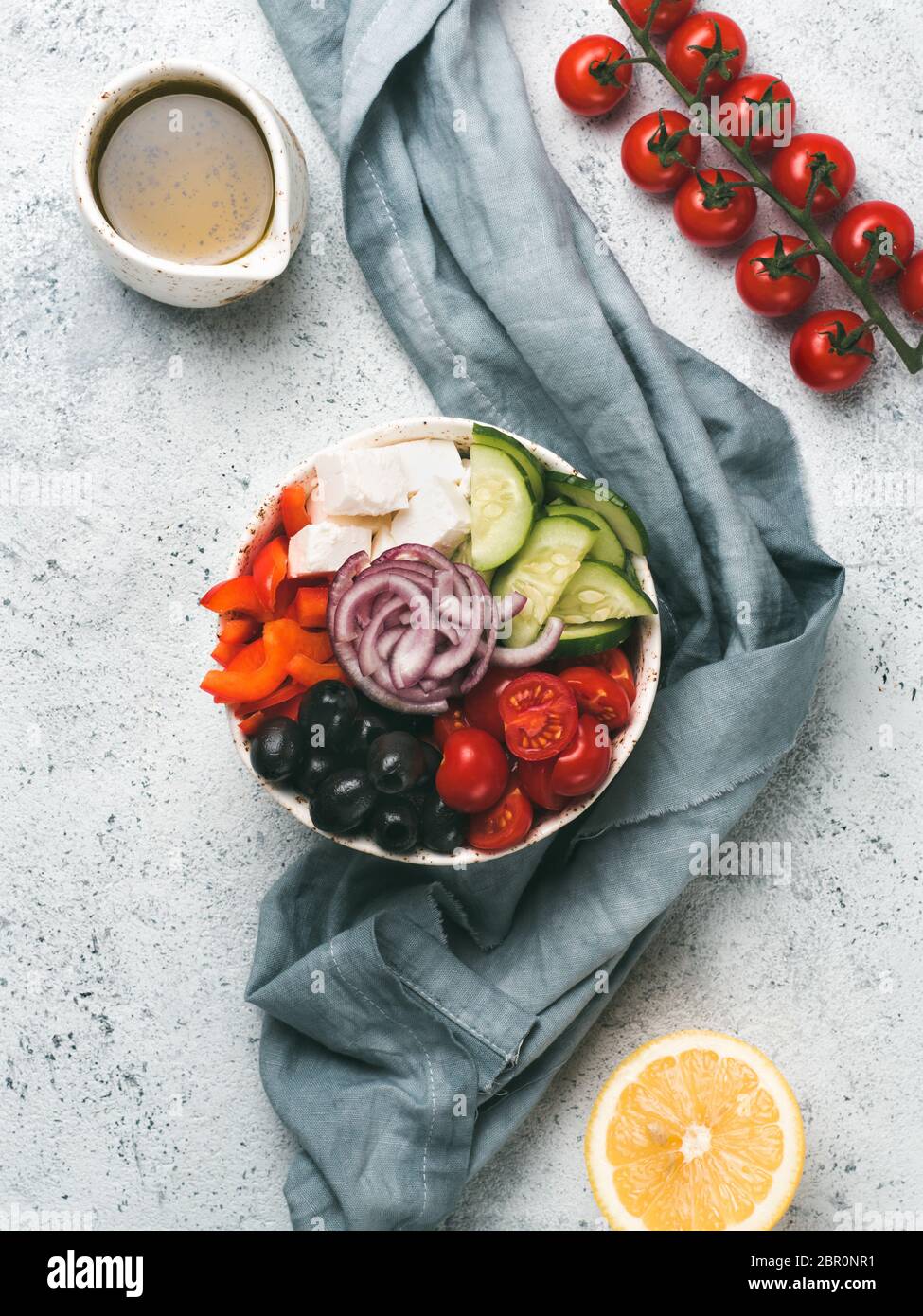 Greek Salad Bowl on gray cement background, copy space. Above view of ...