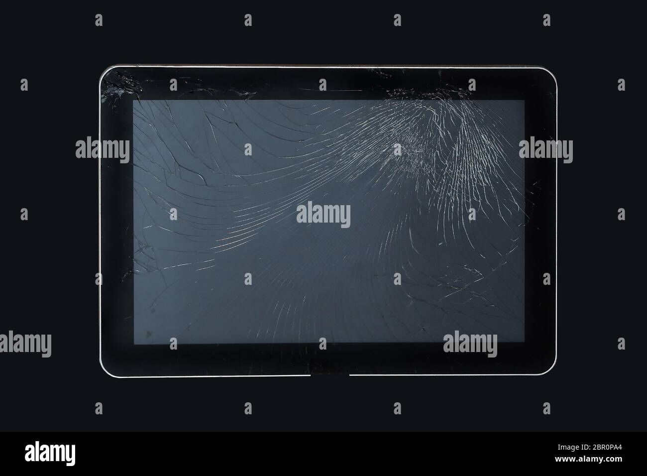 Damaged broken screen glass on modern tablet device isolated on black ...