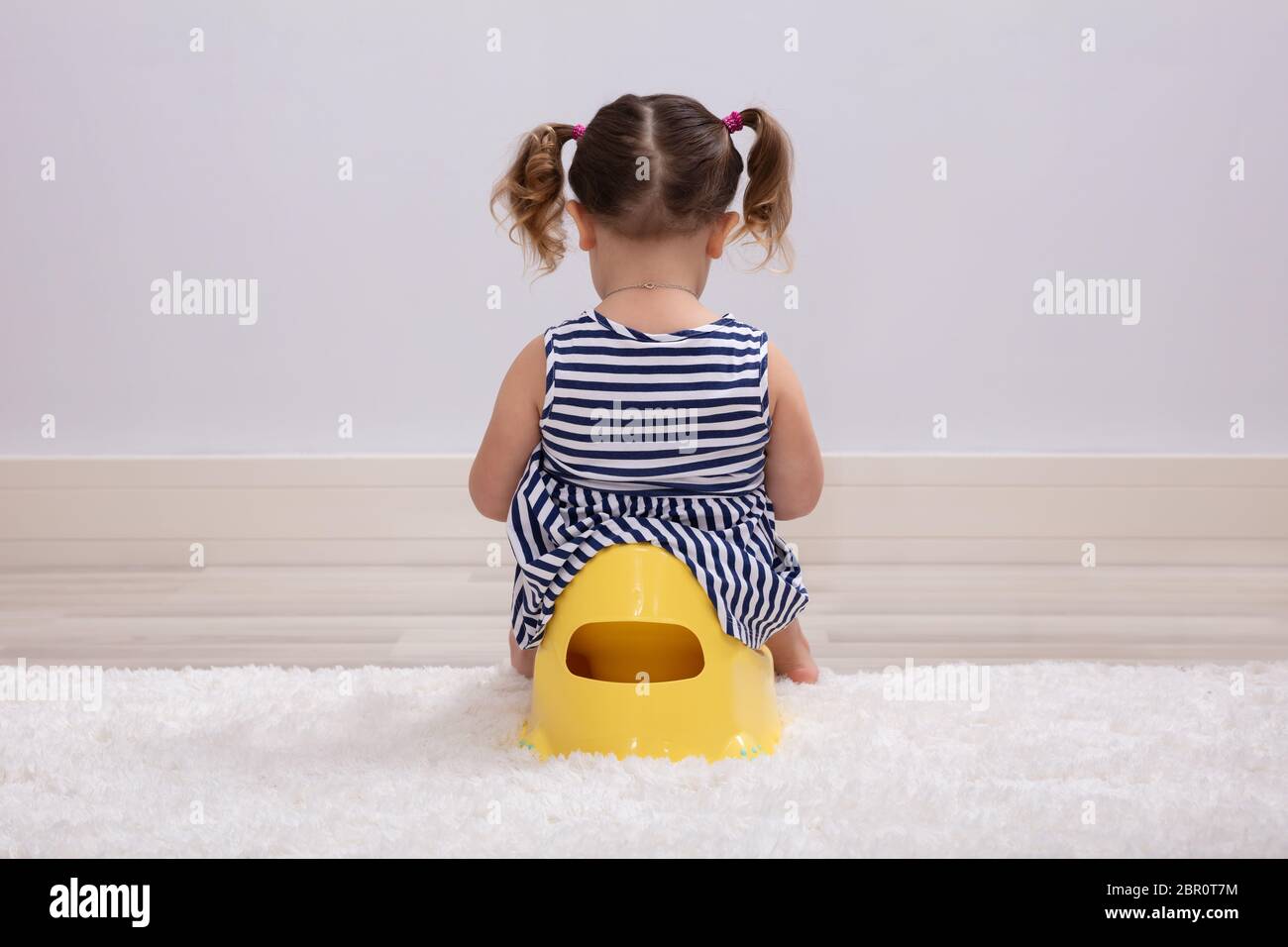 Rear View Of Female Toddler Sitting On A Potty Pot Stock Photo - Alamy