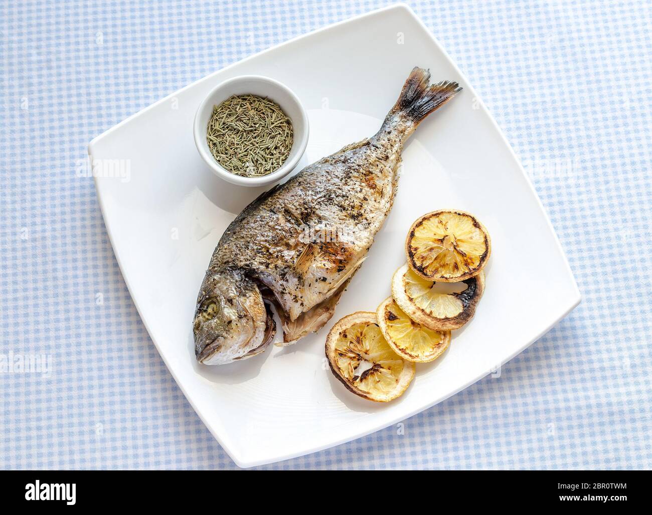 Grilled dorada fish with lemon and spinach Stock Photo - Alamy