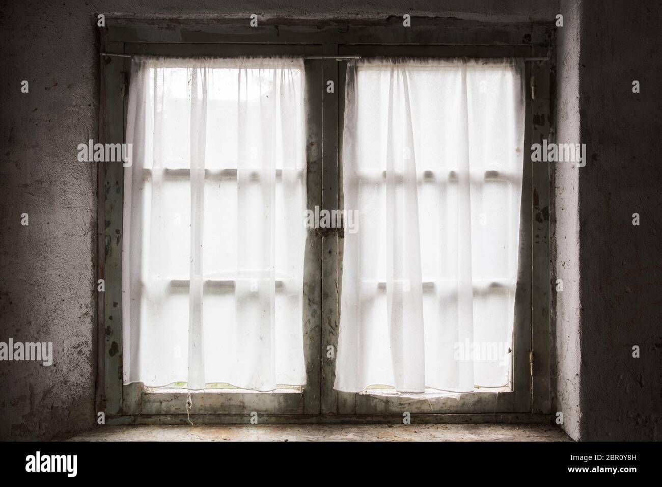 Dark old window with bricks and curtain, light coming through, darkness ...