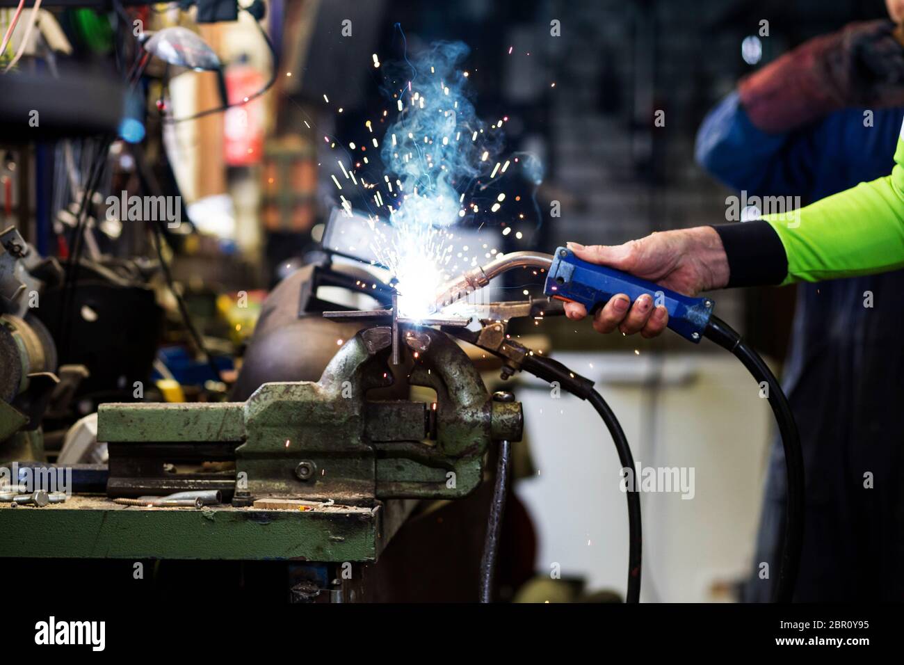Welder is welding in the garage,industrial Worker labourer at the ...
