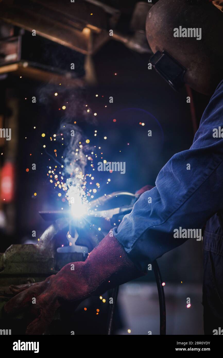 Welder is welding in the garage,industrial Worker labourer at the ...