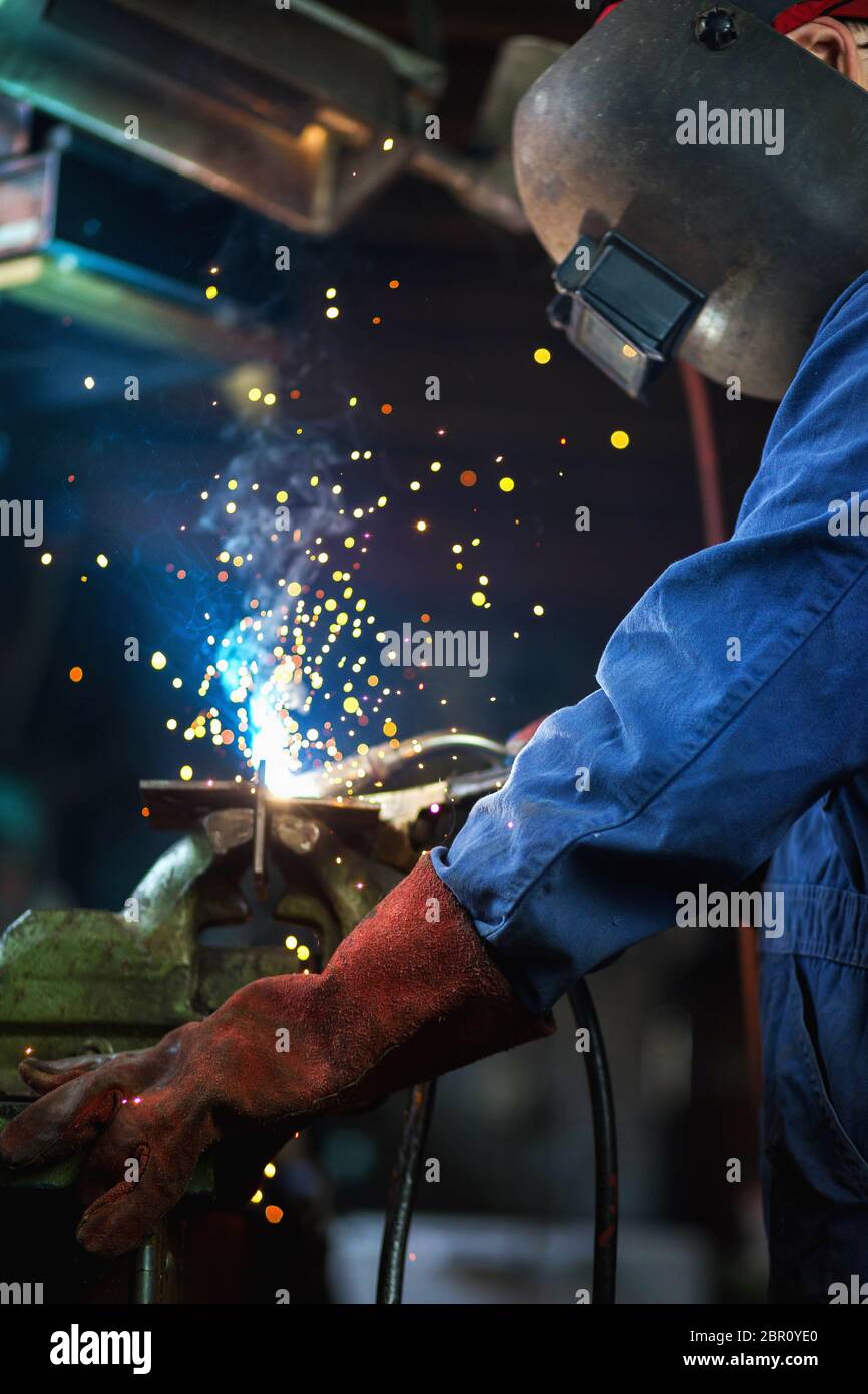 Welder is welding in the garage,industrial Worker labourer at the ...