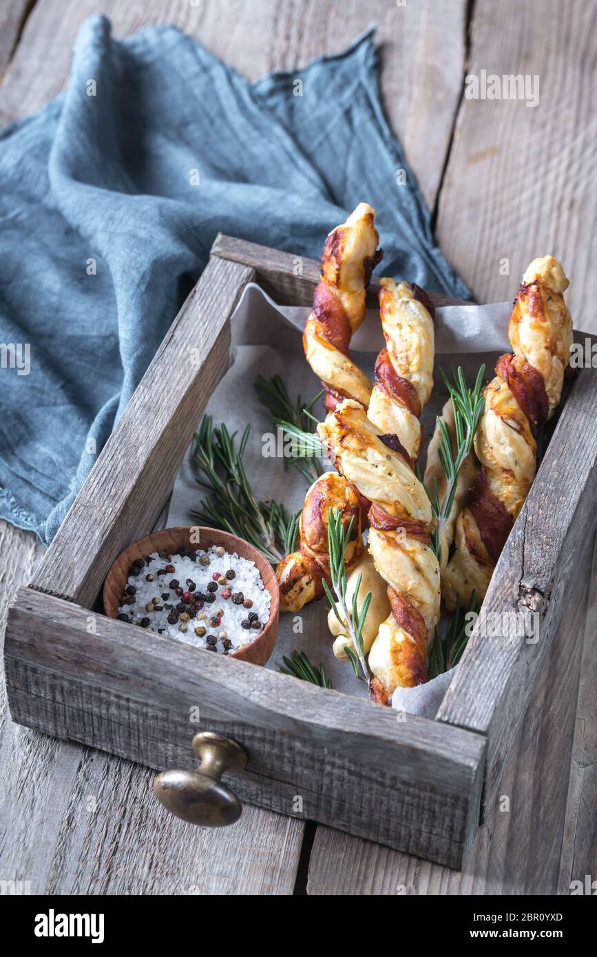Bacon-wrapped breadsticks on the wooden tray Stock Photo - Alamy