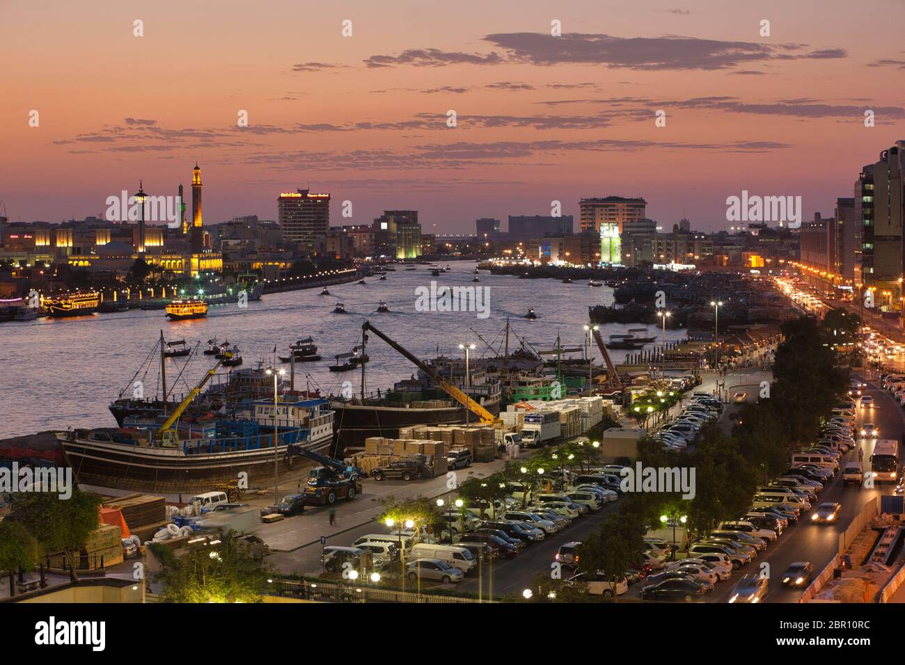 Dubai Creek in Dubai at dusk active with boats and dhows of all sizes ...
