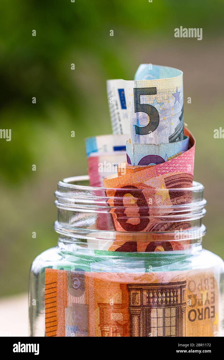 Composition with saving money banknotes in a glass jar. Concept of ...