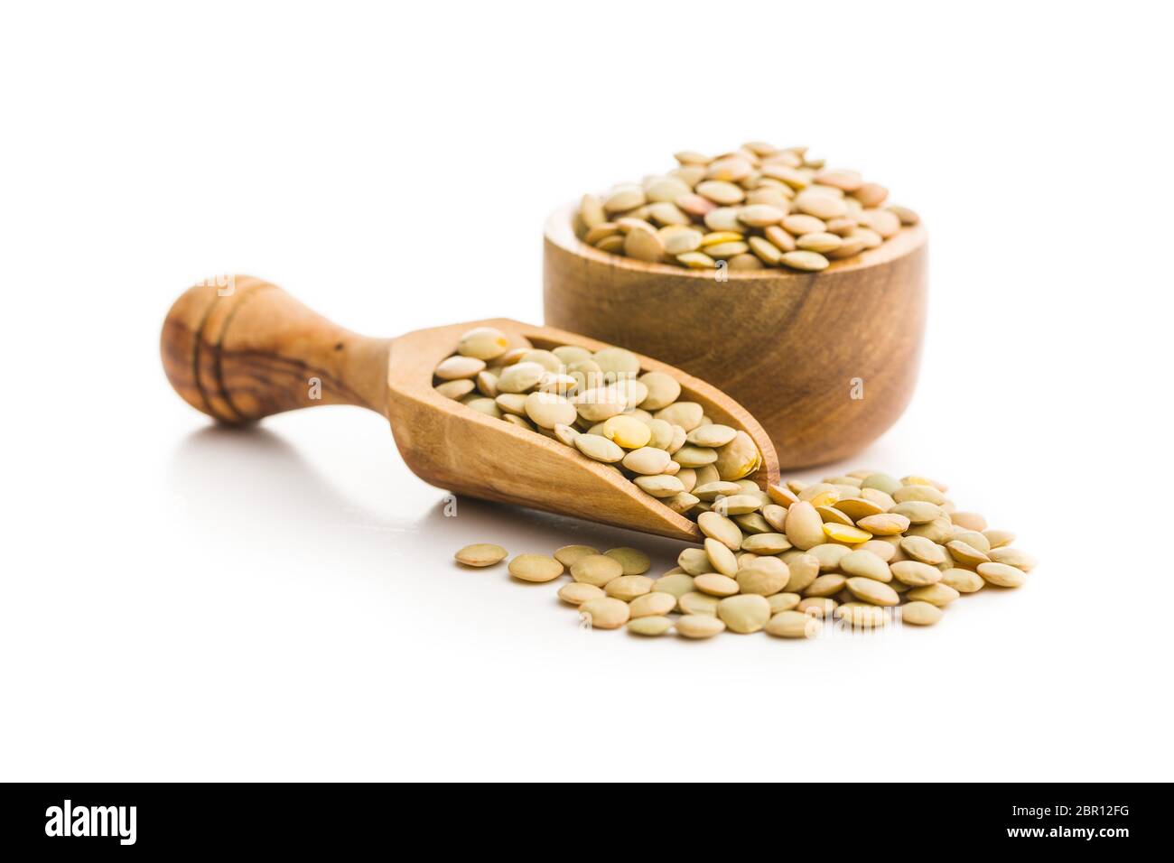 Uncooked dried lentil in wooden scoop isolated on white background ...