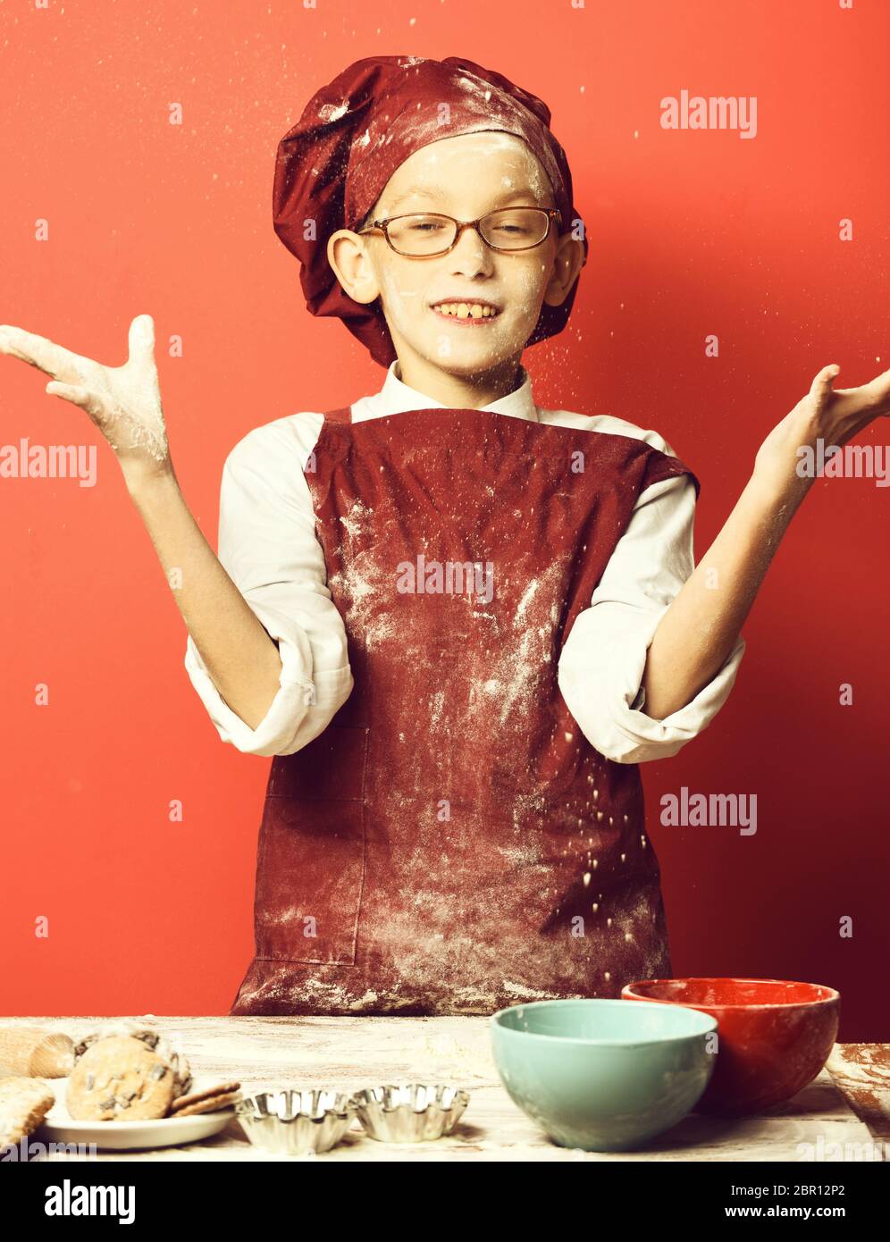 young boy cute cook chef in uniform and hat on stained surprised face ...