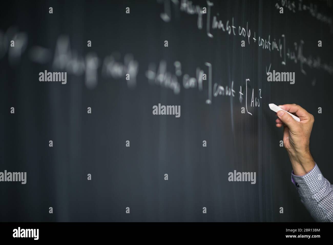 Math teacher by the blackboard during mathclass - detail of the hand ...