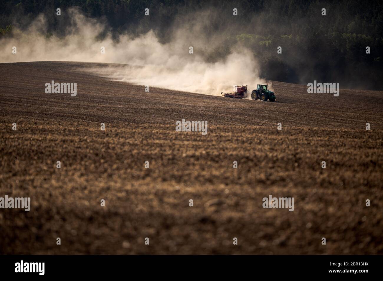 Tractor plowing a dry farm field - acute drought the soil suffers from ...