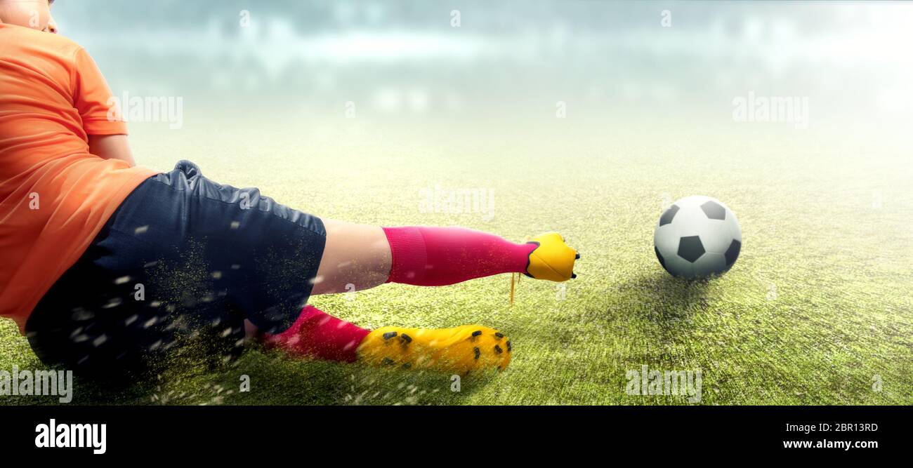 Asian football player woman in orange jersey sliding tackle the ball on ...