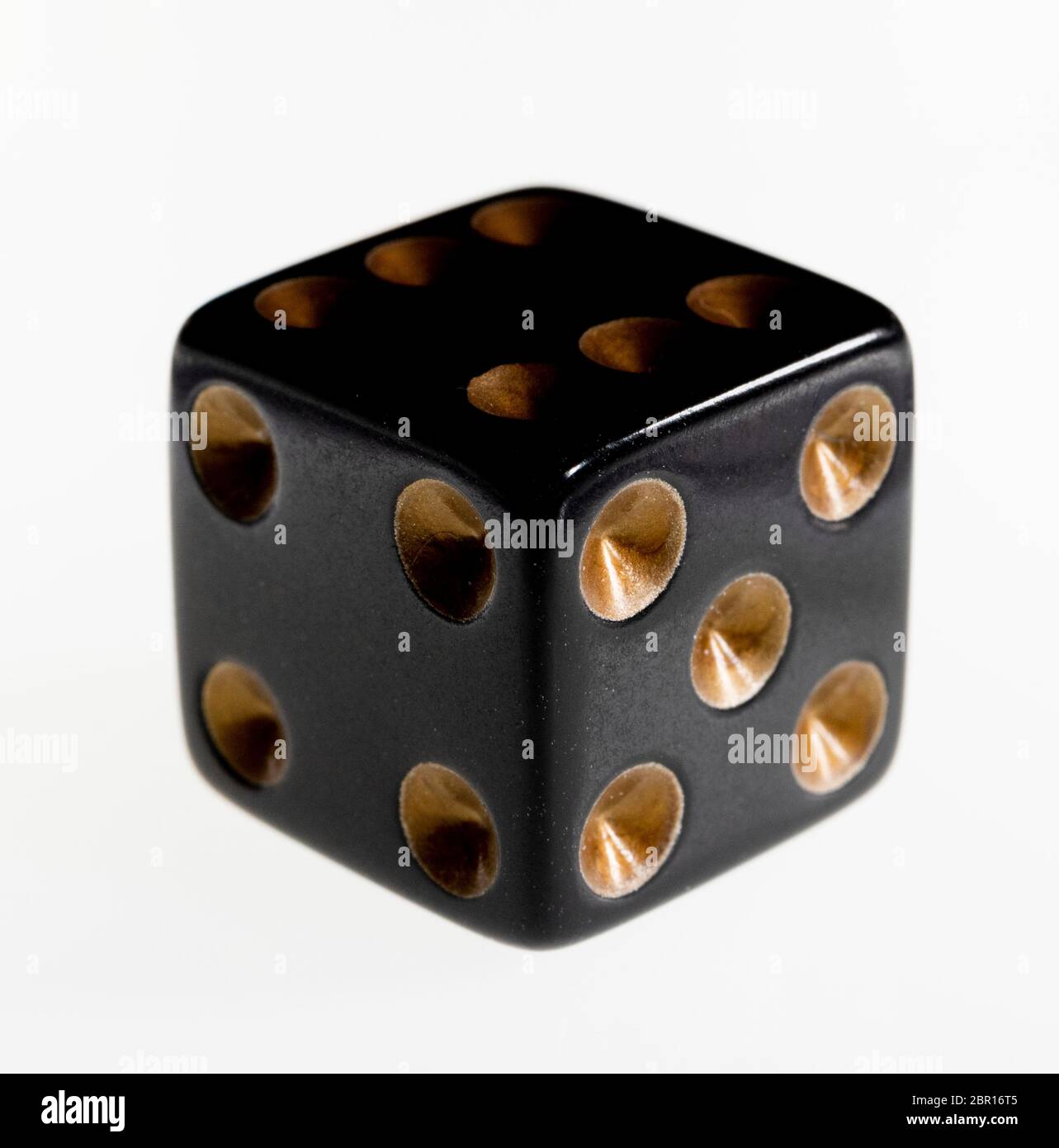 One black dice against a white background Stock Photo - Alamy
