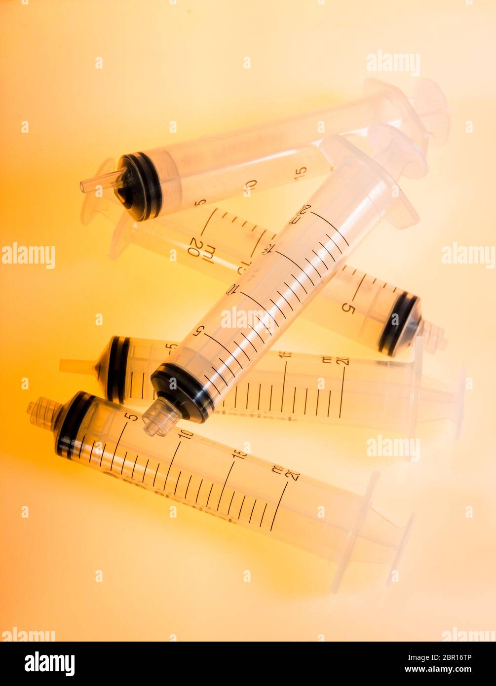 Group of syringes on orange background Stock Photo - Alamy