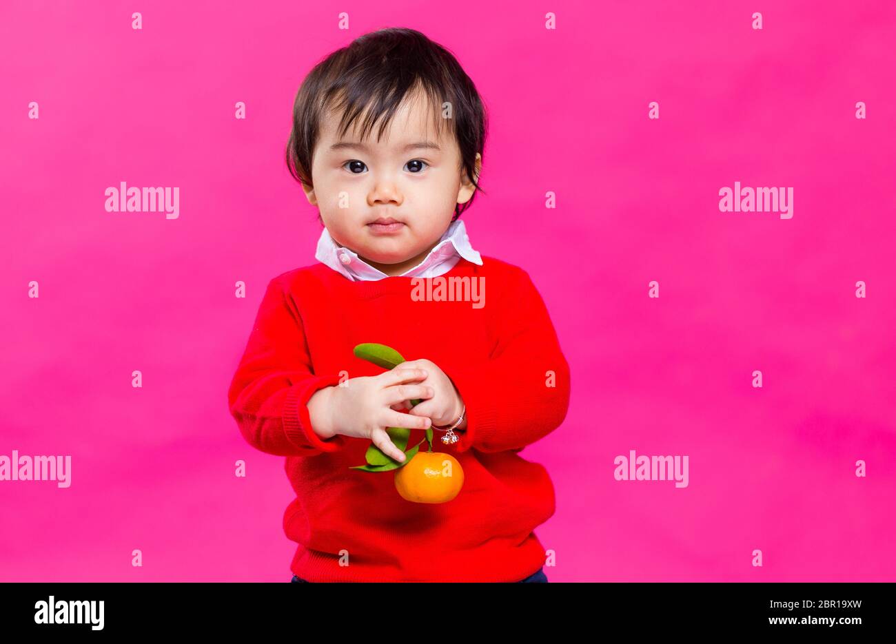 Asian little boy holding Mandarin Stock Photo - Alamy