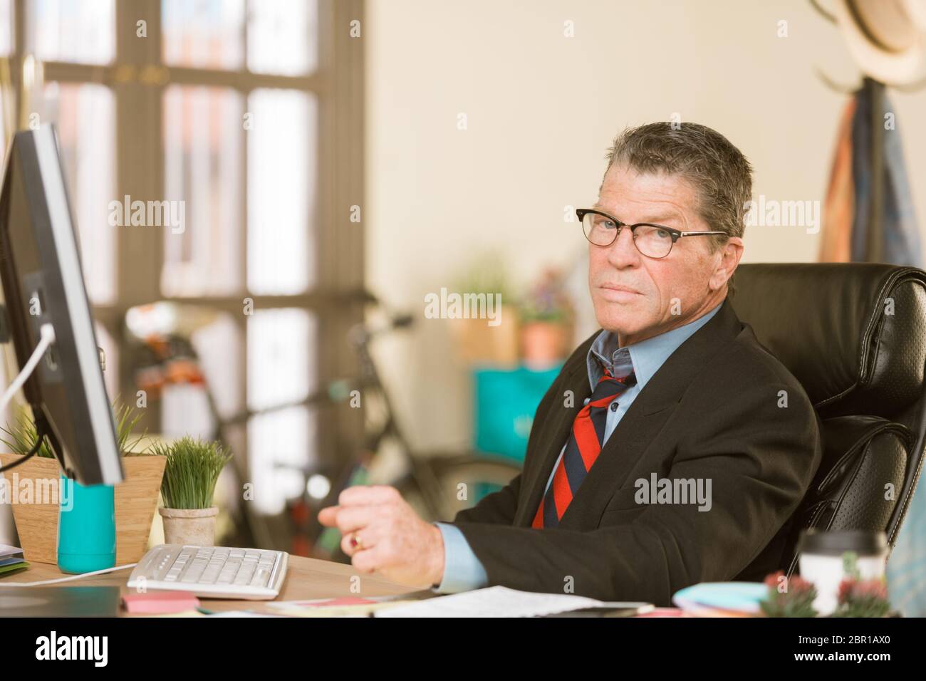 Skeptical man working at his desk Stock Photo - Alamy