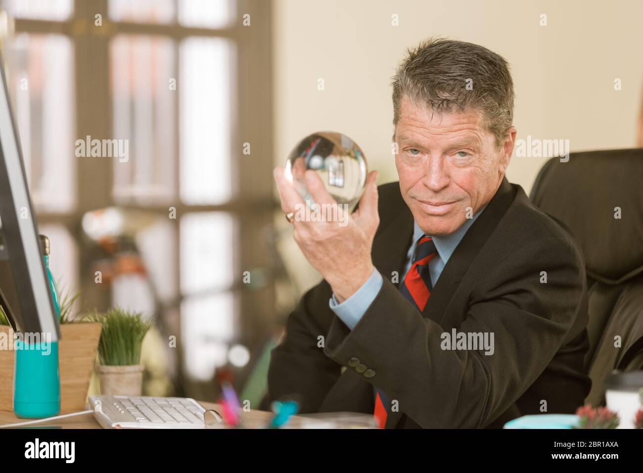 Confident professional man with a crystal ball Stock Photo - Alamy