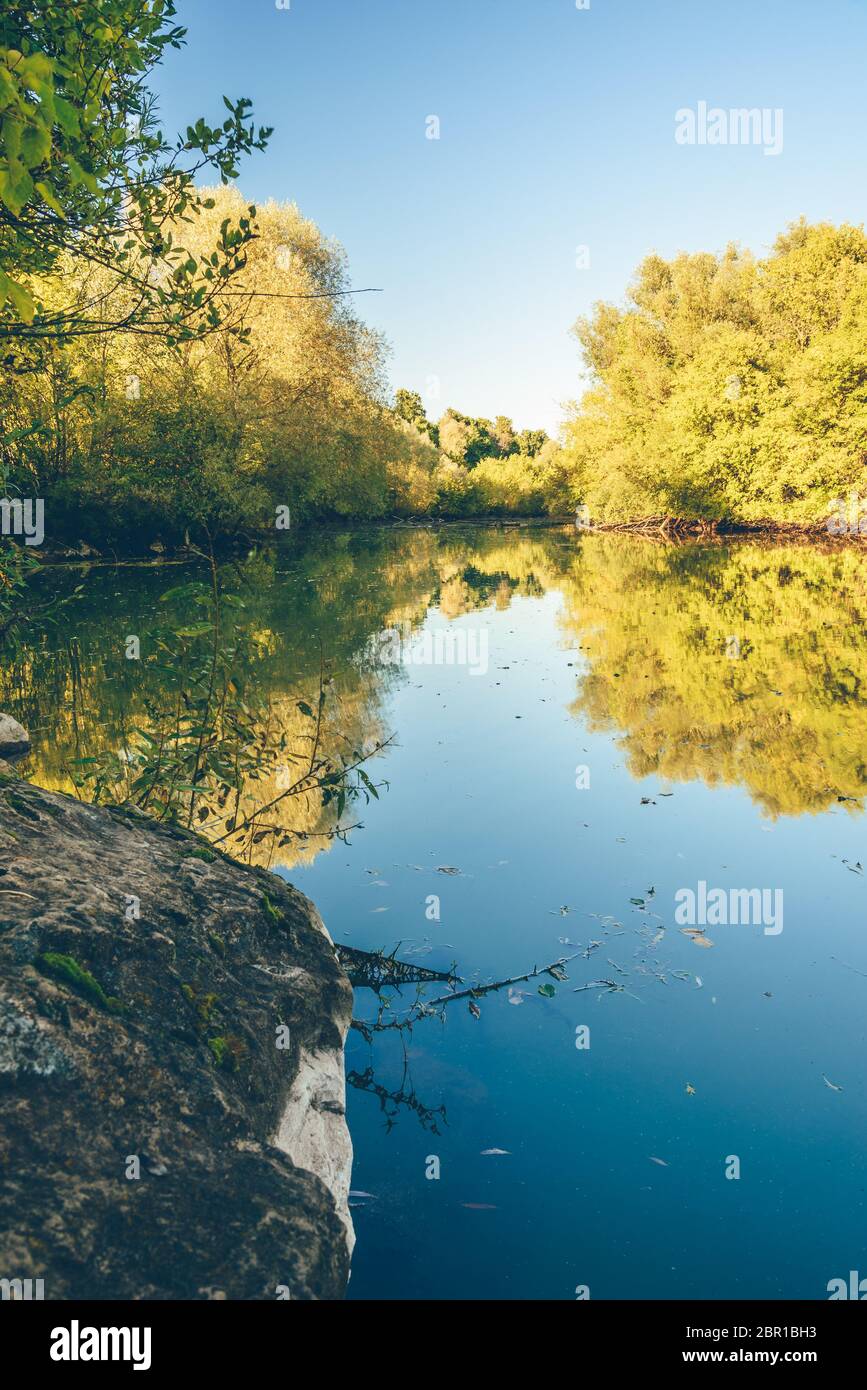 Autumn forest with reflection on water surface of blue lake Stock Photo ...