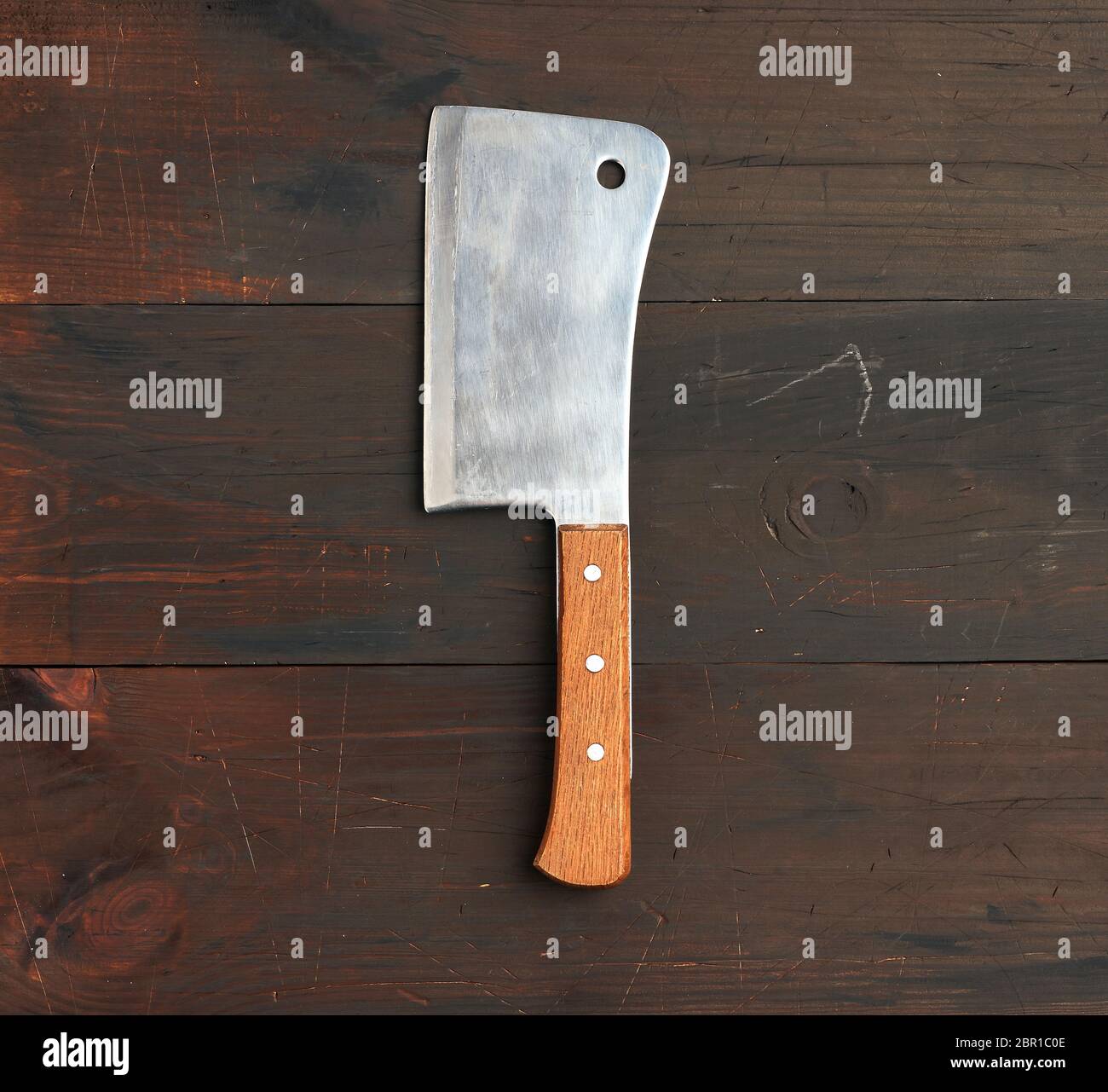 large kitchen knife for cutting meat and vegetables on a brown wooden ...