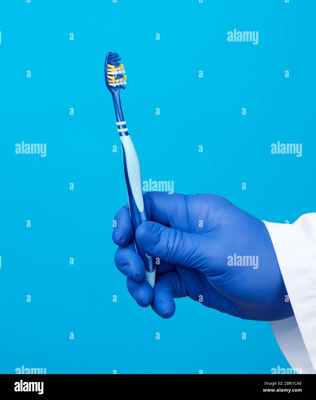 doctor therapist is dressed in a white robe uniform and blue sterile ...
