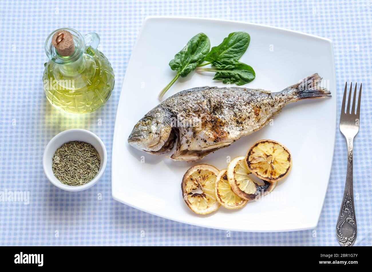 Grilled dorada fish with lemon and spinach Stock Photo - Alamy