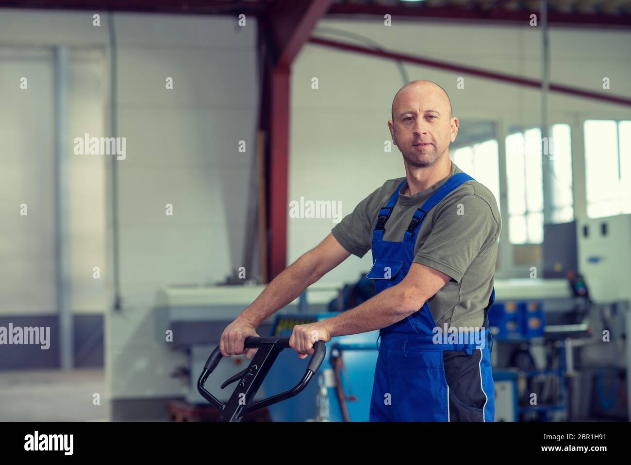one worker in factory with hand lift Stock Photo - Alamy
