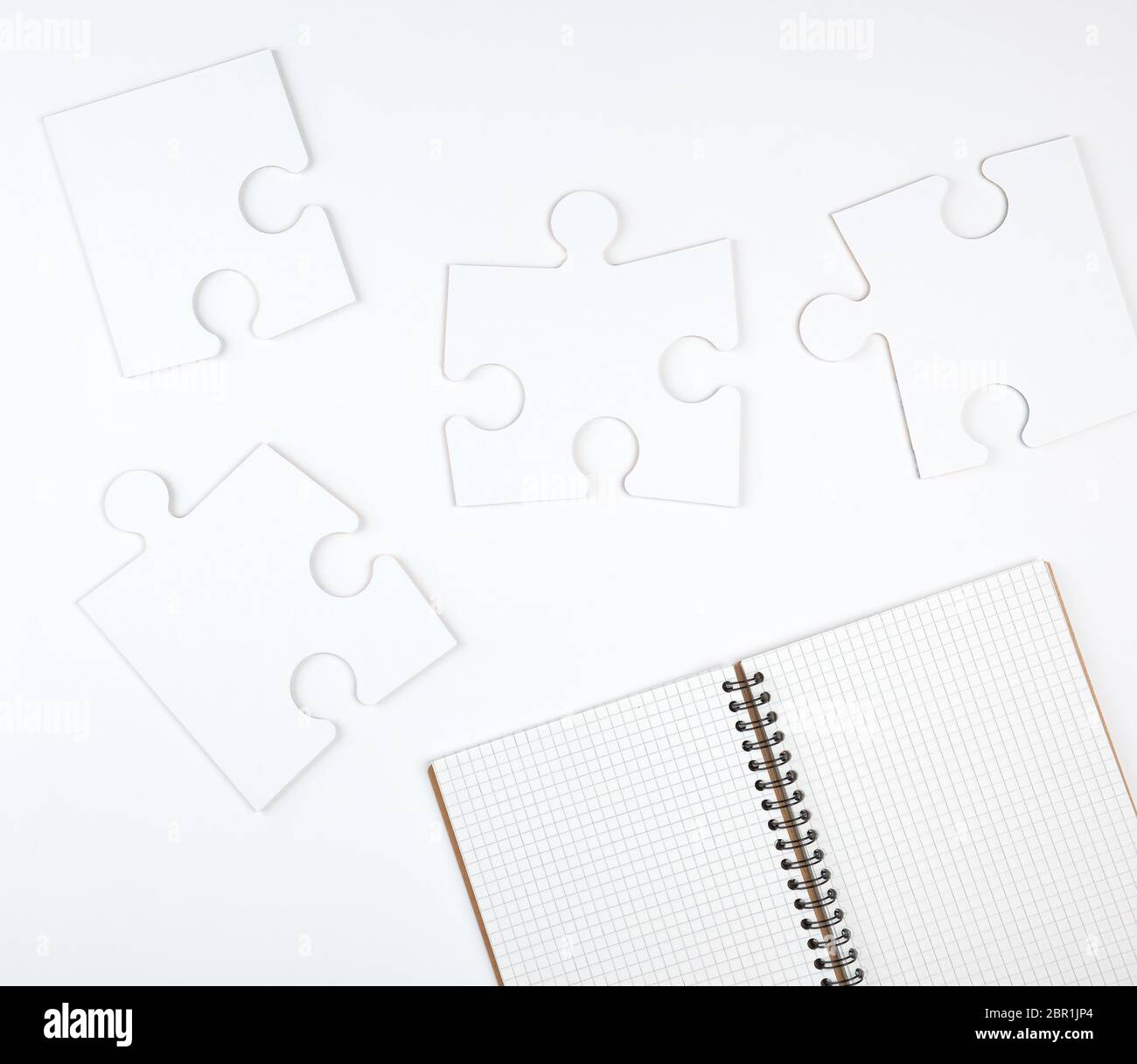 open notebook in a cell and on a white background, next to large blank ...