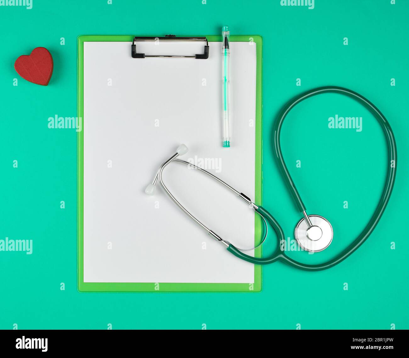 empty white sheets and a medical stethoscope on a green background ...