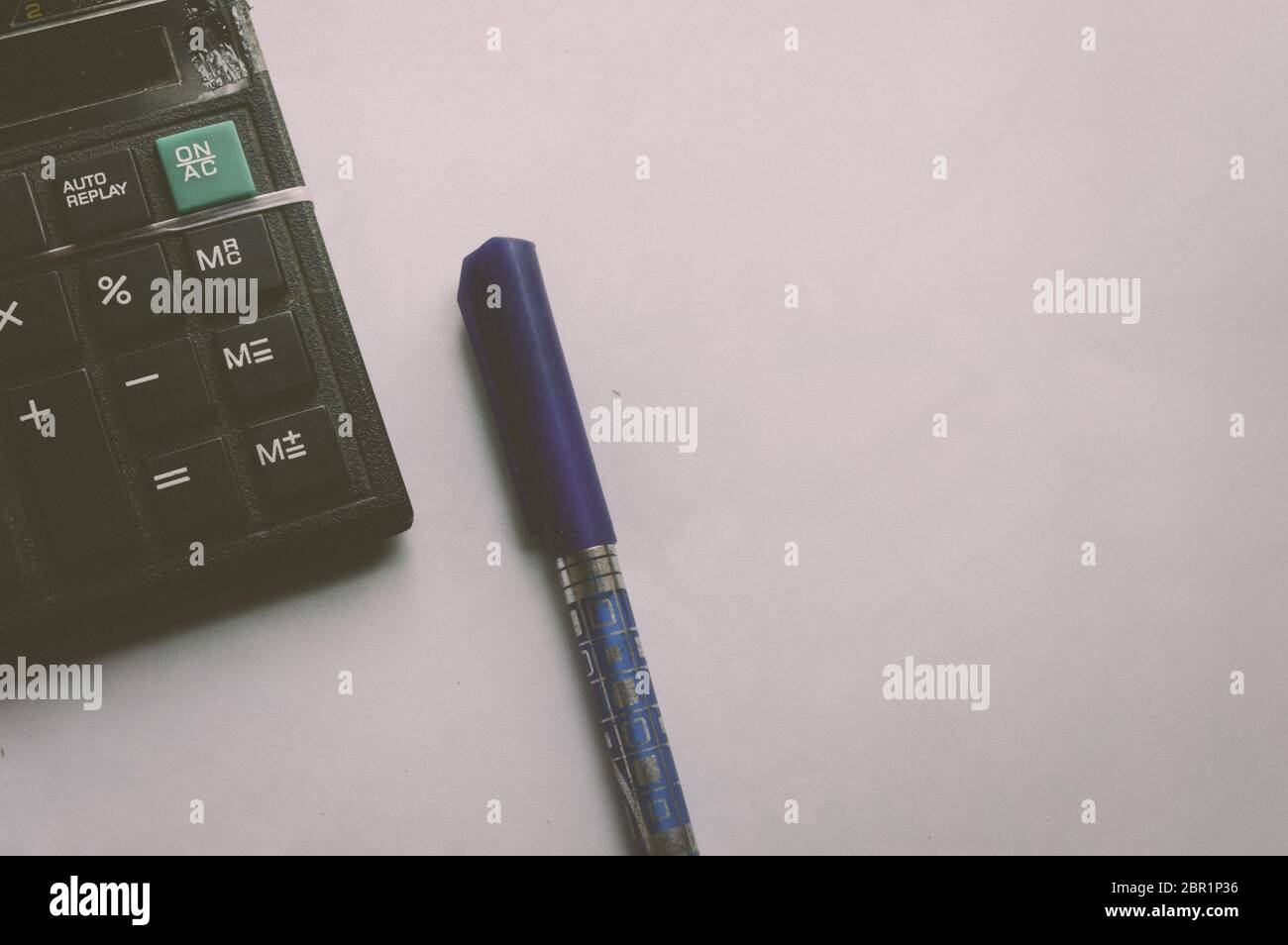 pen and calculator or calculating machine on white background ...