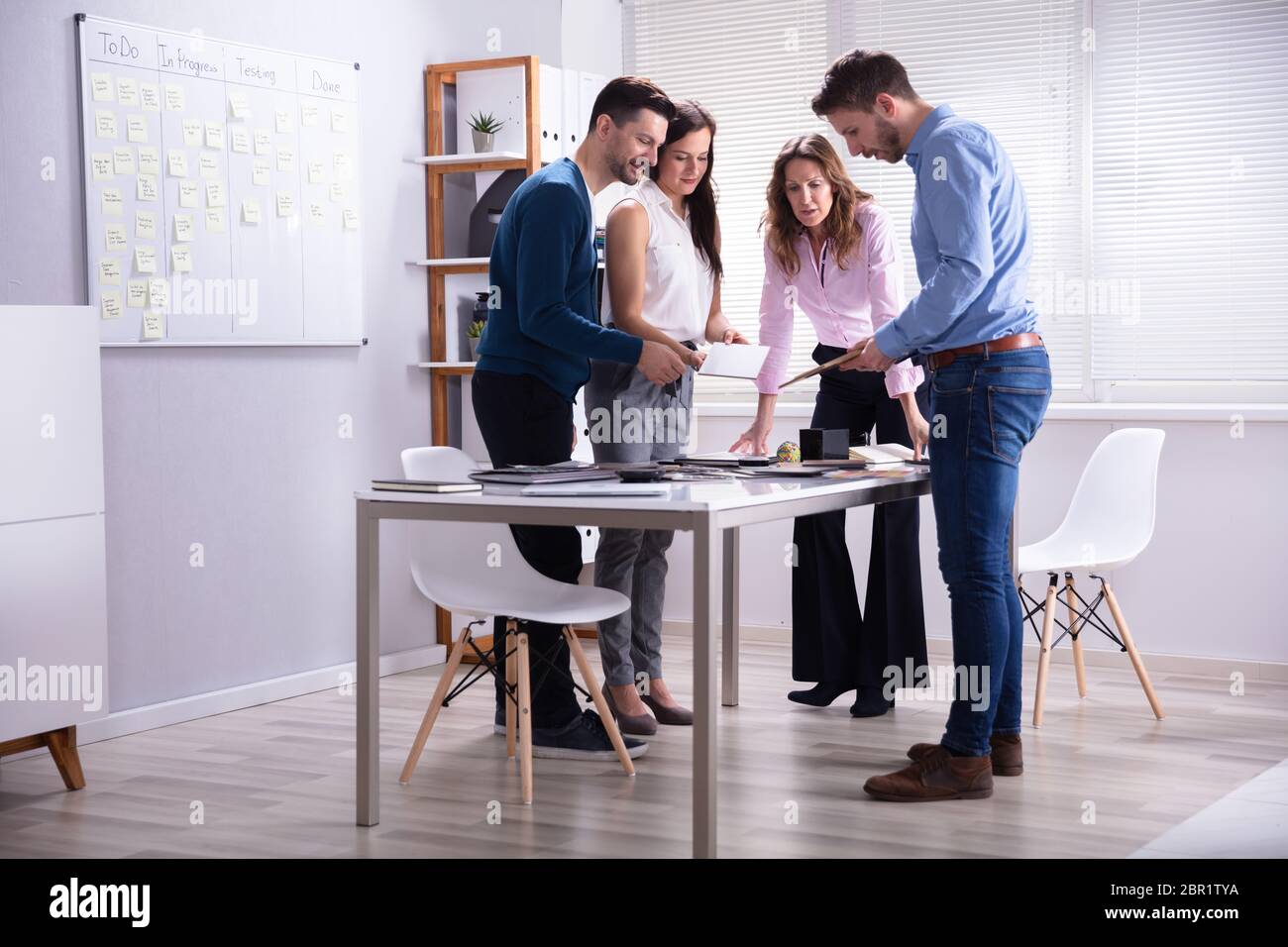 Group Of Young Businesspeople Working Together Choosing Color Palette ...
