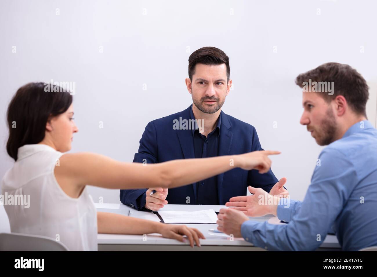 Young Couple Arguing With Each Other In Front Of Judge At Courtroom ...