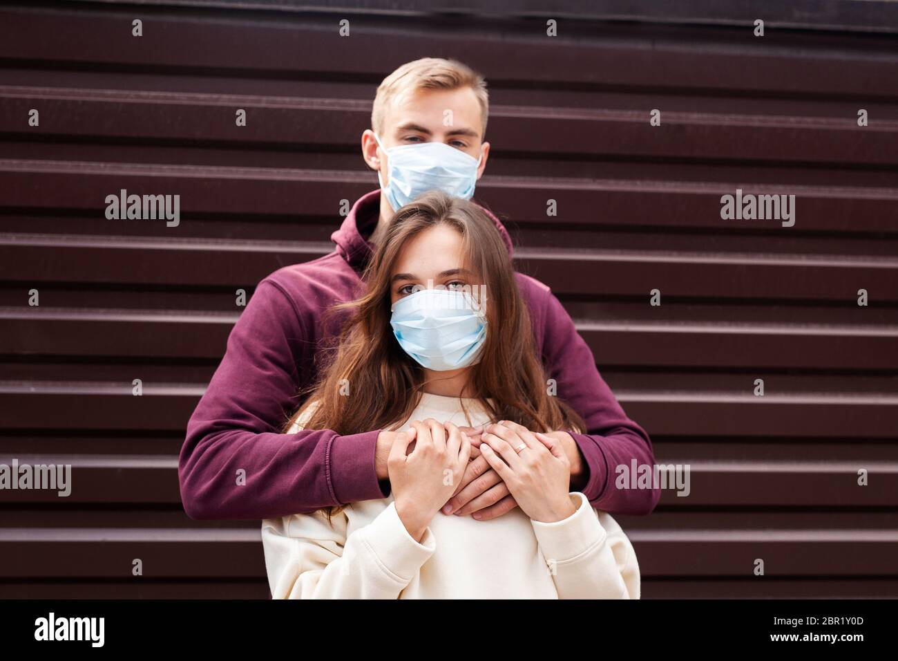Young scared couple hugging wearing a face protection mask in the city ...
