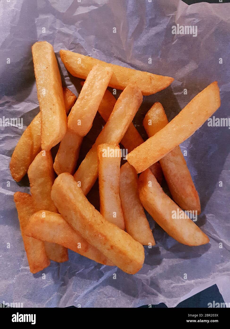 Serving of oven roasted chips on kitchen paper, overhead view Stock ...