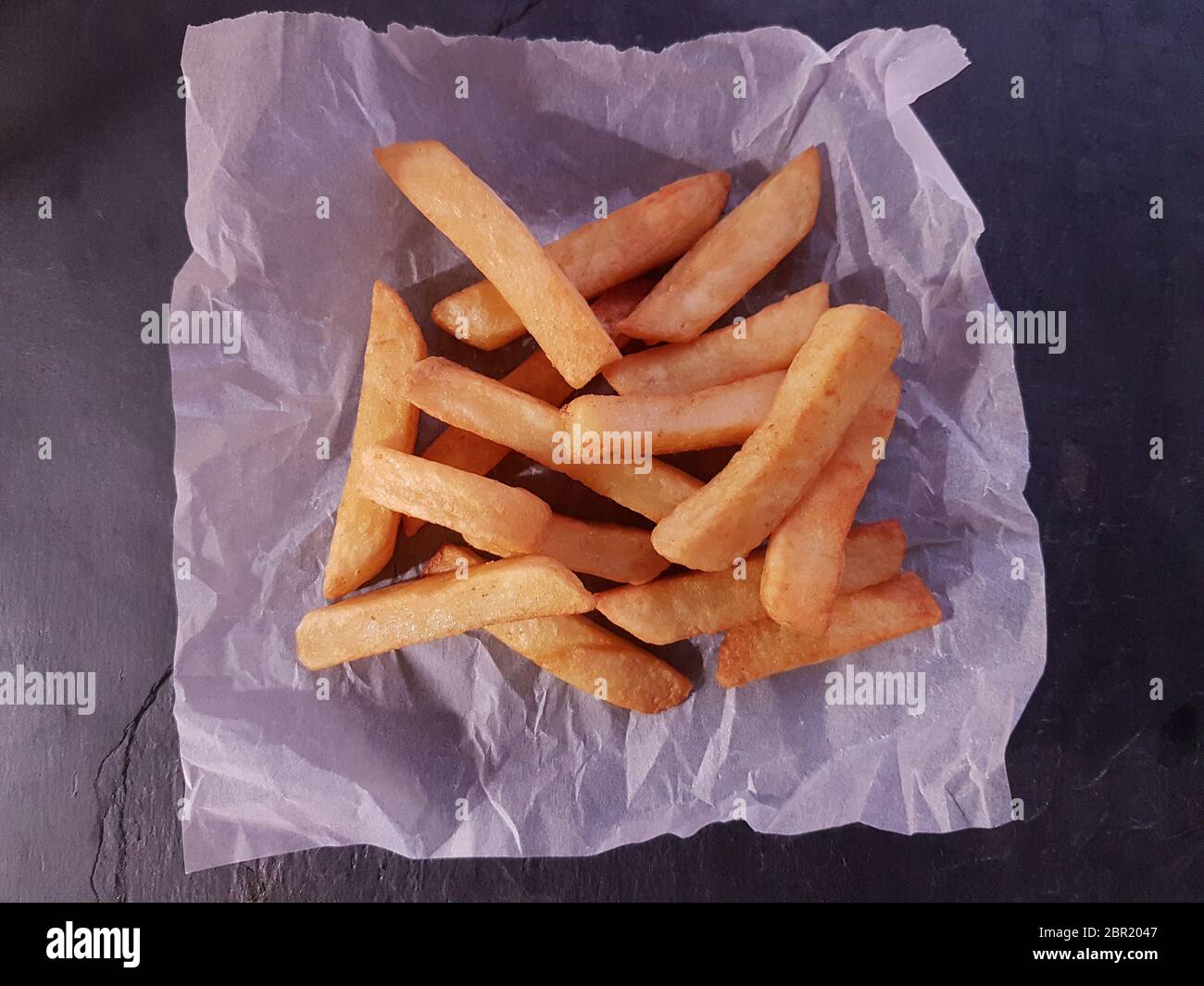 Serving of oven roasted chips on kitchen paper, overhead view Stock ...