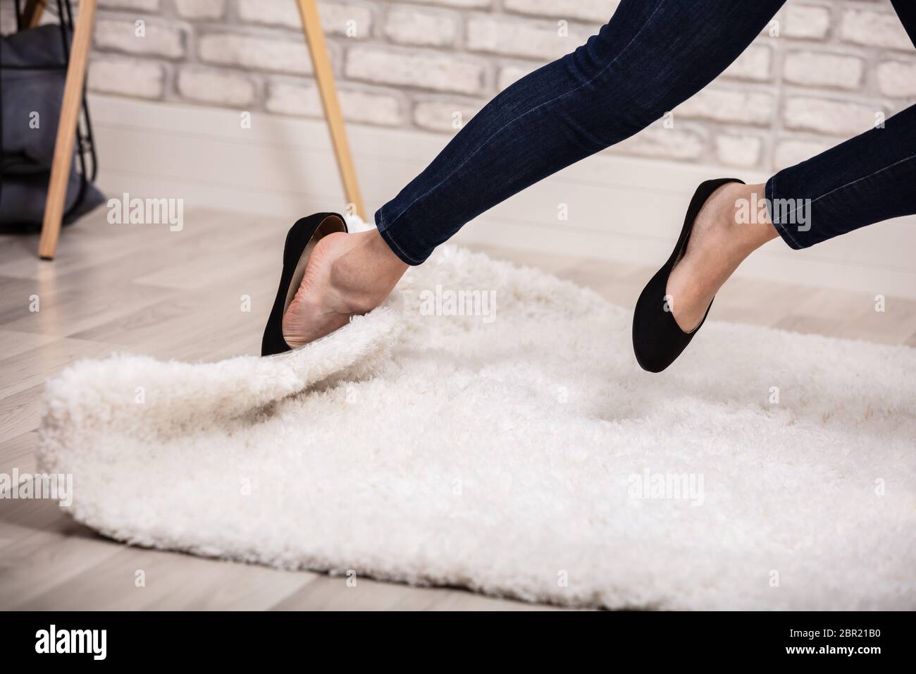 Low Section Of Woman Stumble In A Carpet Stock Photo - Alamy