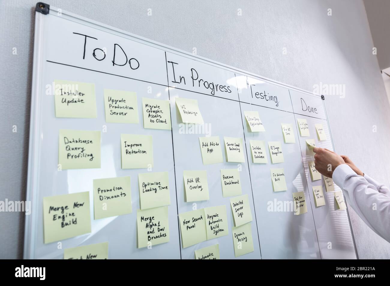 Side View Of Businessman Writing On Sticky Notes Attached To White ...