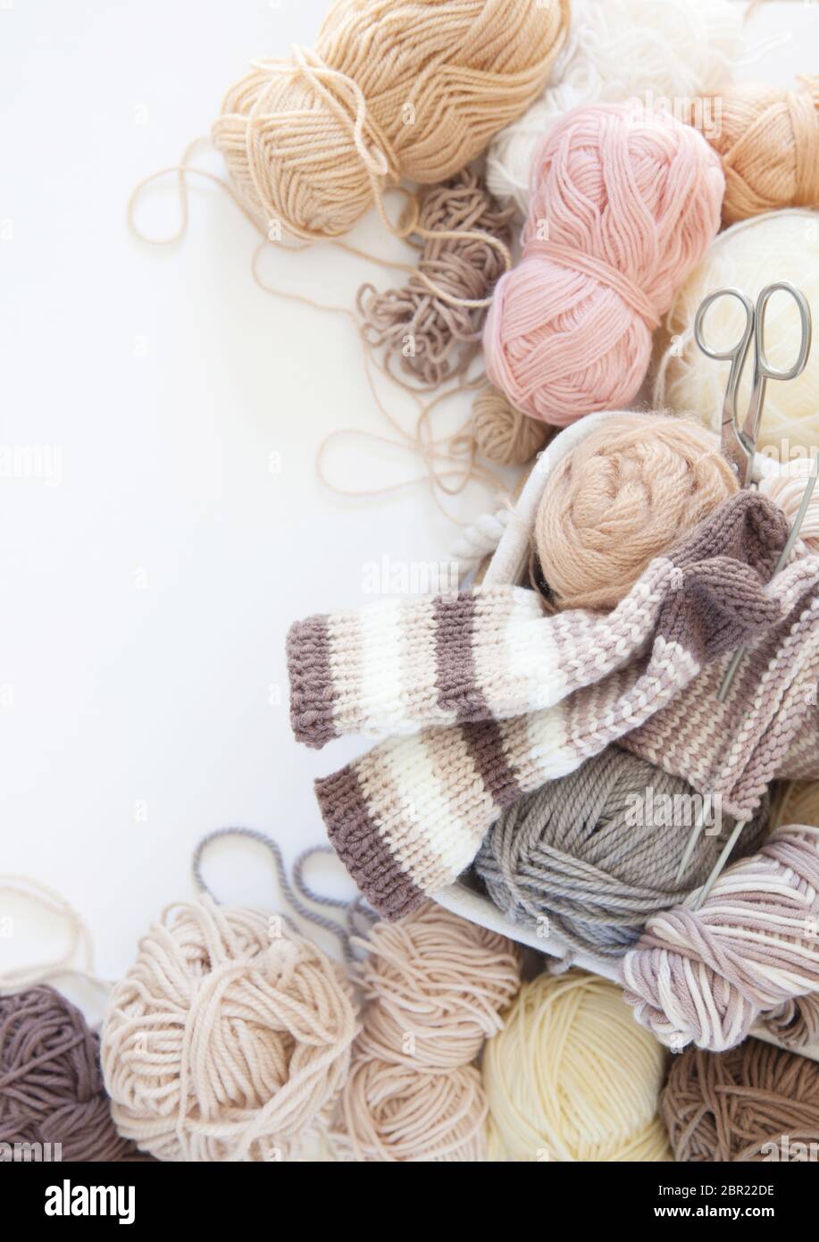 Neutral beige yarn for knitting is in the basket. Woolen warm socks ...