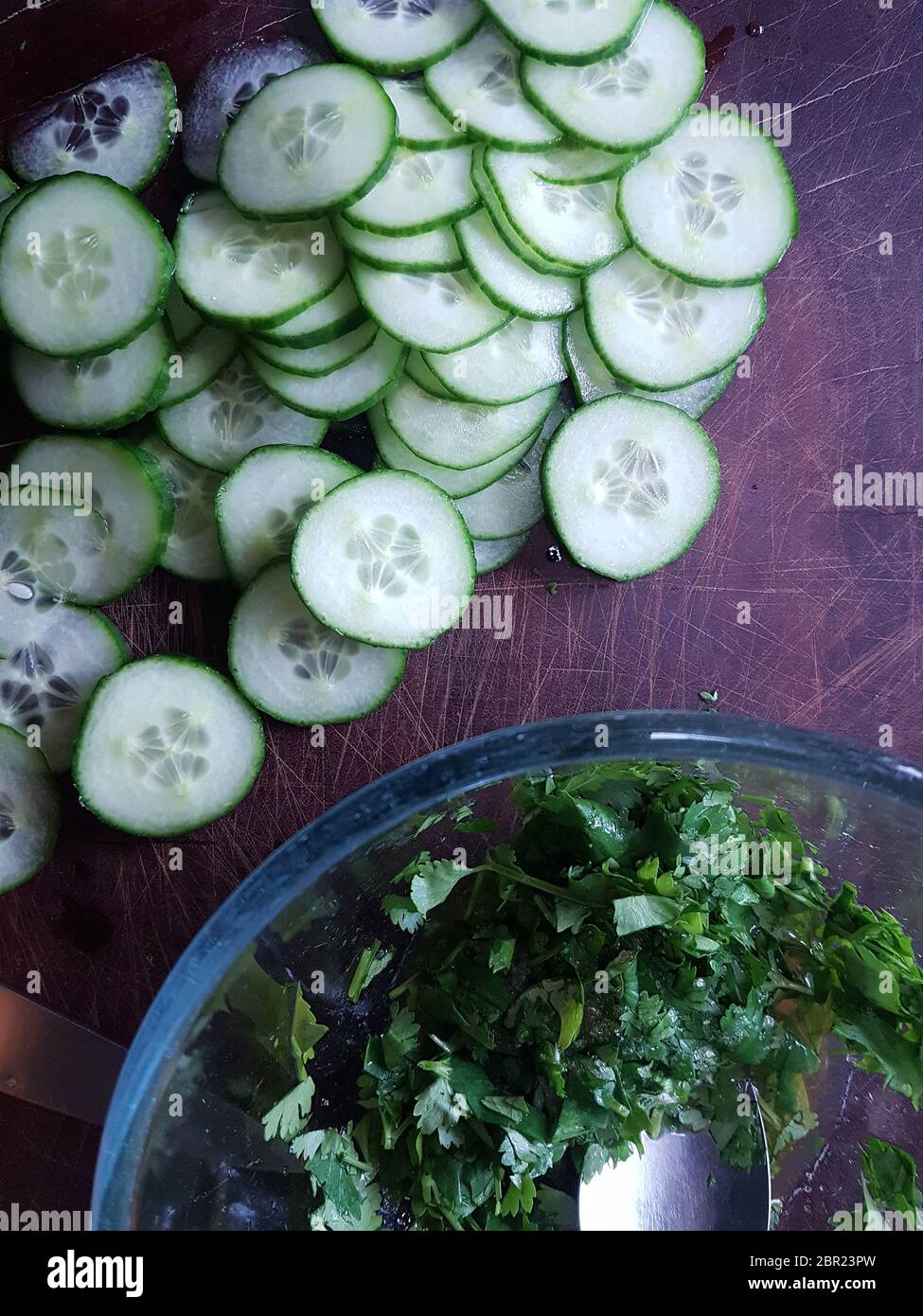 Sliced fresh cucumber and chopped coriander Stock Photo - Alamy