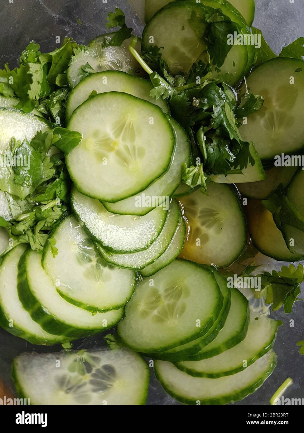 Sliced fresh cucumber and chopped coriander Stock Photo - Alamy
