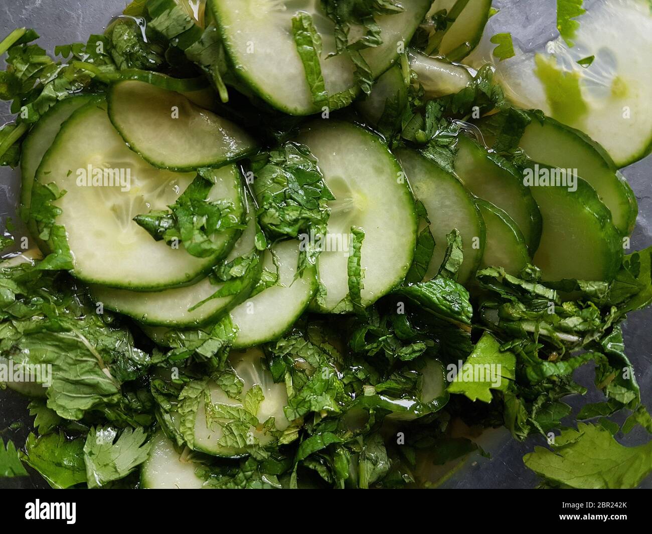 Sliced fresh cucumber and chopped coriander Stock Photo - Alamy