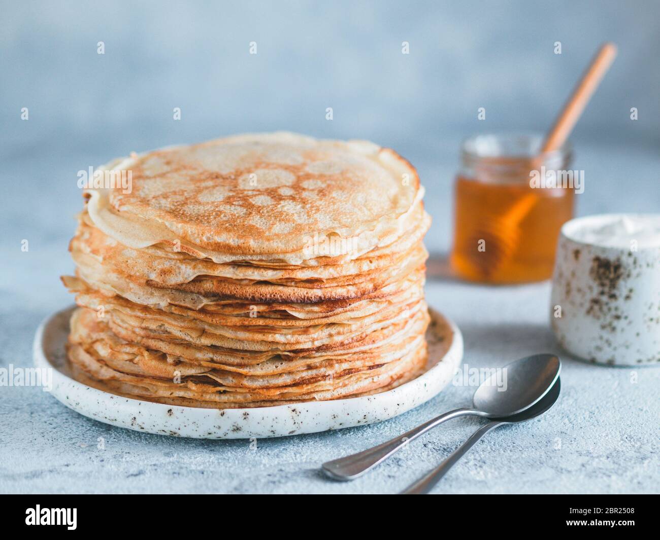Stack of traditional russian pancakes blini on gray background with ...